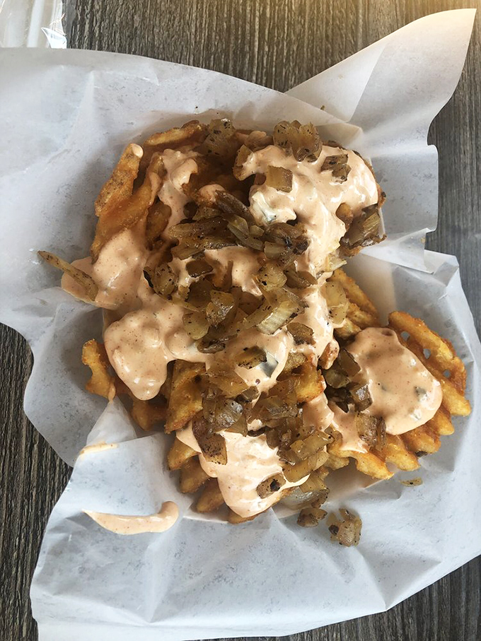 Waffle fries dressed in sauce and grilled onions&mdash;proof that even side dishes deserve their moment in the spotlight.