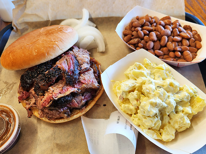 The holy trinity of Texas comfort: brisket sandwich, creamy potato salad, and beans. A balanced diet by Lone Star standards.