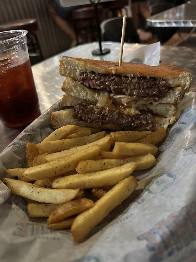 The patty melt that launched a thousand food dreams. Two perfectly grilled slices of bread embrace beef patties and melted cheese in a sandwich love story.
