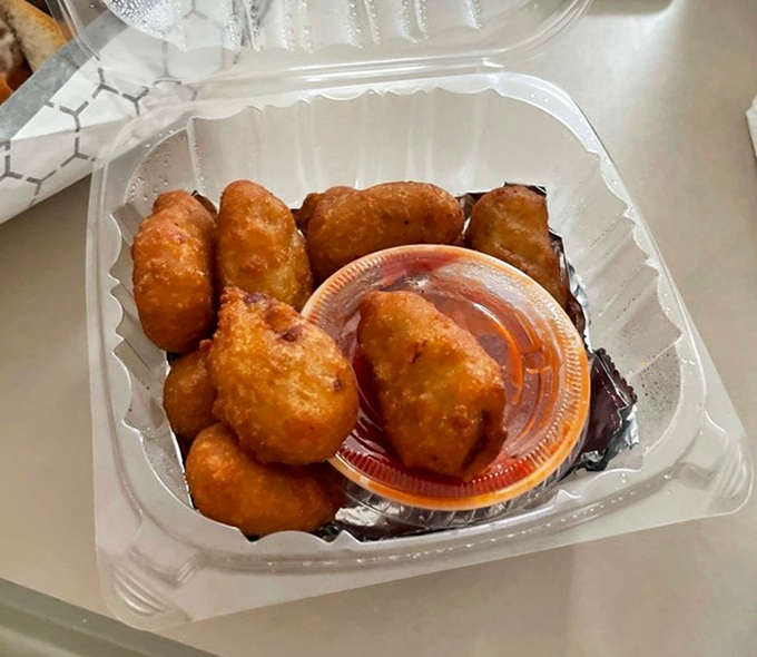 Golden-fried corn nuggets sitting pretty next to dipping sauce—proof that sometimes the best things in life come in small, crispy packages.
