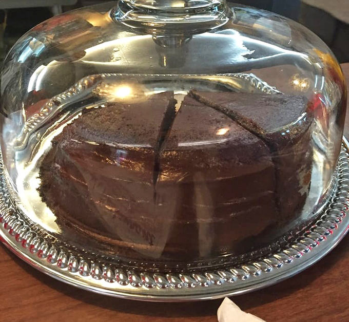 Beneath that glass dome lies chocolate cake so rich it should have its own tax bracket. Save room or live with regret&mdash;your choice.