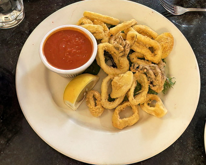 Fried calamari so perfectly golden, it deserves its own Olympic medal. Crispy, tender, and ready for its marinara sauce bath.