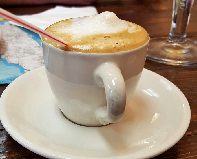 The caf&eacute; con leche arrives with a perfect foam crown &ndash; Miami's liquid energy that puts fancy coffee chains to shame.