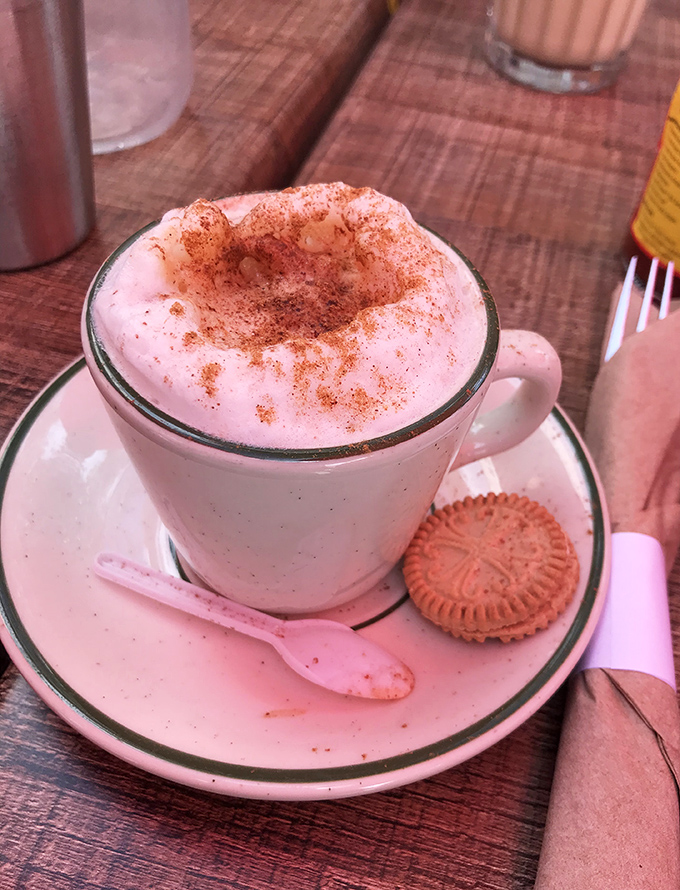 Coffee elevated to an art form, topped with foam so perfect it deserves its own Instagram account. The cookie? Just a bonus act of kindness.
