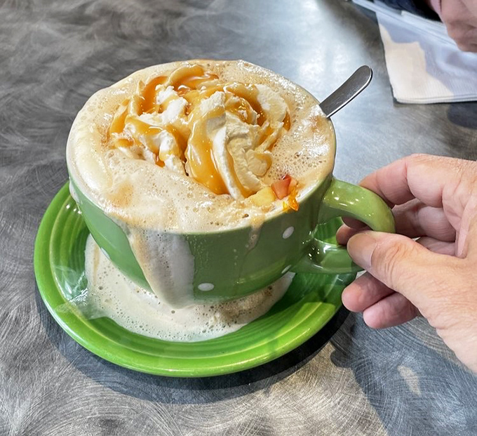 Coffee elevated to an art form. This caramel-drizzled creation in its polka-dotted green mug isn't just a beverage&mdash;it's morning motivation in liquid form.