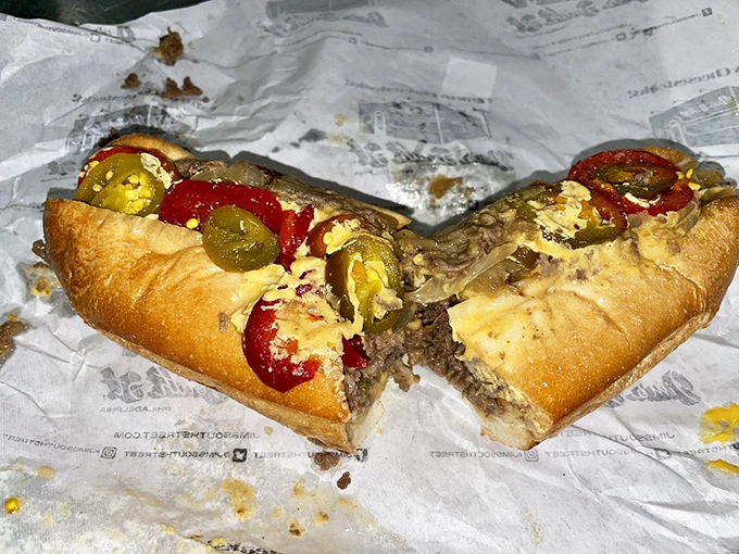 The money shot: a cheesesteak in its natural habitat, cut in half to reveal the beautiful marriage of meat, cheese, and peppers within.