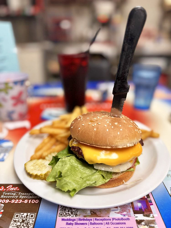 A classic American cheeseburger with the knife standing at attention &ndash; as if it knows it's guarding something truly special.