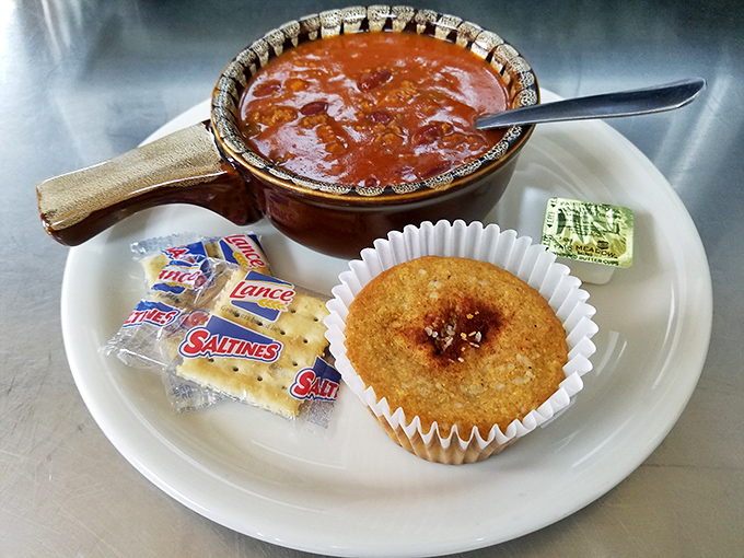 Homemade chili in its rustic serving dish with a corn muffin sidekick. Like a warm hug on a plate, Pennsylvania-style.