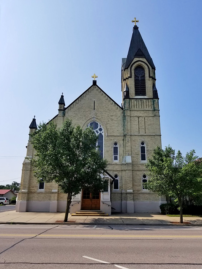 The Church of St. Thomas the Apostle reaches skyward with timeless dignity, its limestone facade glowing warmly in the Wisconsin sunshine.