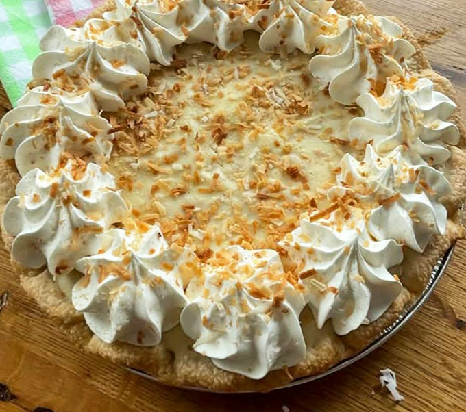 Whipped cream peaks circle this coconut cream masterpiece like a delicious mountain range, with toasted coconut flakes for added texture.