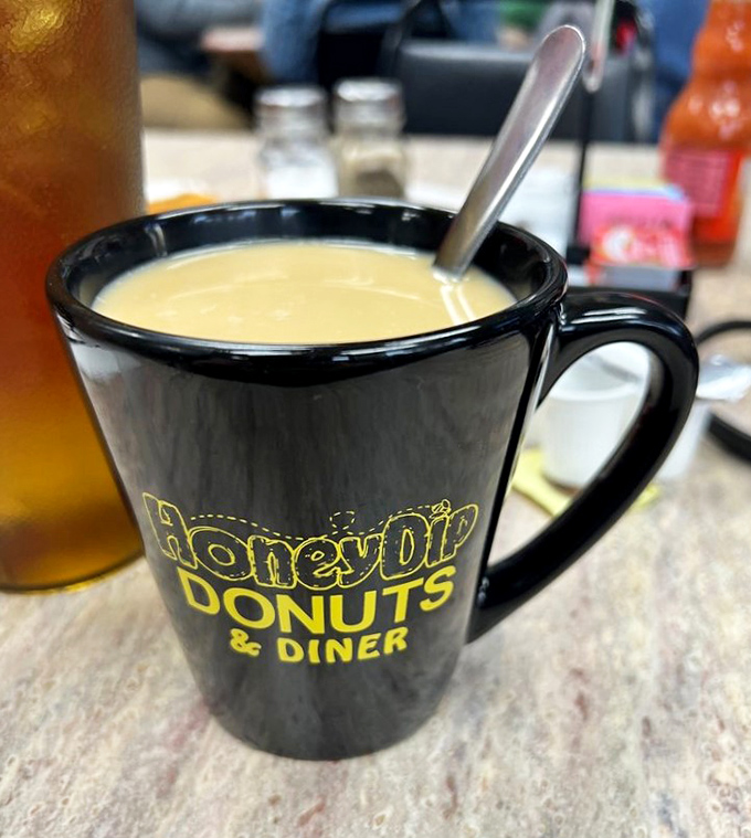 That black mug with yellow lettering isn't just holding coffee &ndash; it's cradling liquid motivation, served with a side of local pride.