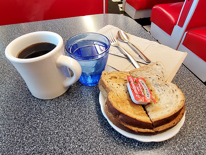 The holy trinity of diner breakfasts: sturdy ceramic mug, bottomless coffee, and golden toast. Simple pleasures that somehow taste better under fluorescent lights.