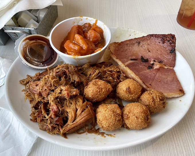 BBQ heaven on a plate &ndash; pulled pork, country ham, and hush puppies create a trifecta of Southern flavors that demands to be savored.