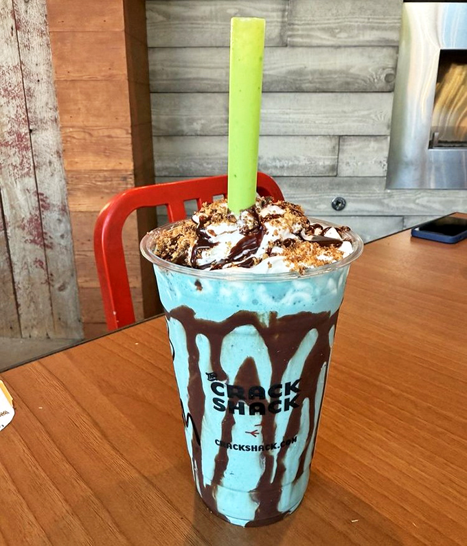 This isn't just a milkshake&mdash;it's dessert architecture, with chocolate cascading down blue soft-serve like a sweet Jackson Pollock painting.