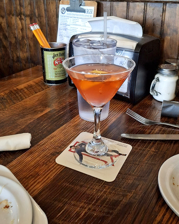 Even the cocktails get the royal treatment&mdash;this peachy-pink martini sitting on a rustic wooden table proves Burger Tavern 77 knows liquid refreshment matters too.