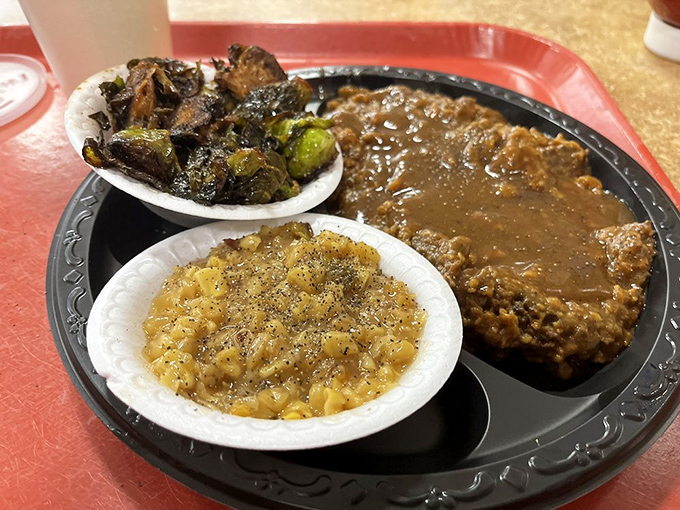 Country fried steak arrives like comfort food royalty, crowned with gravy and flanked by loyal vegetables.