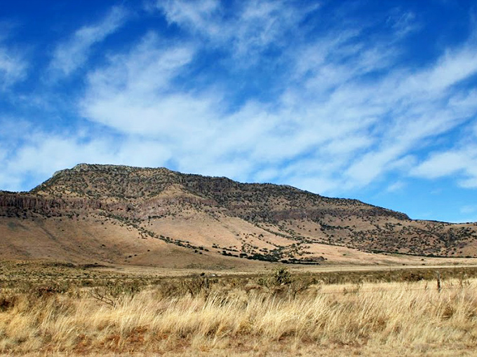 Nature's masterpiece unfolds across the horizon. The Davis Mountains roll away like waves frozen in time under that impossibly blue Texas sky.