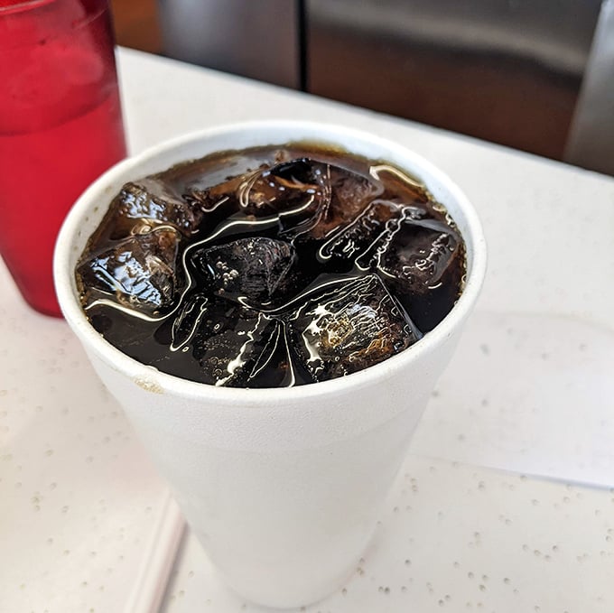 That ice-cold soda, sweating in its styrofoam cup, is the perfect companion for taming a burger that means business.
