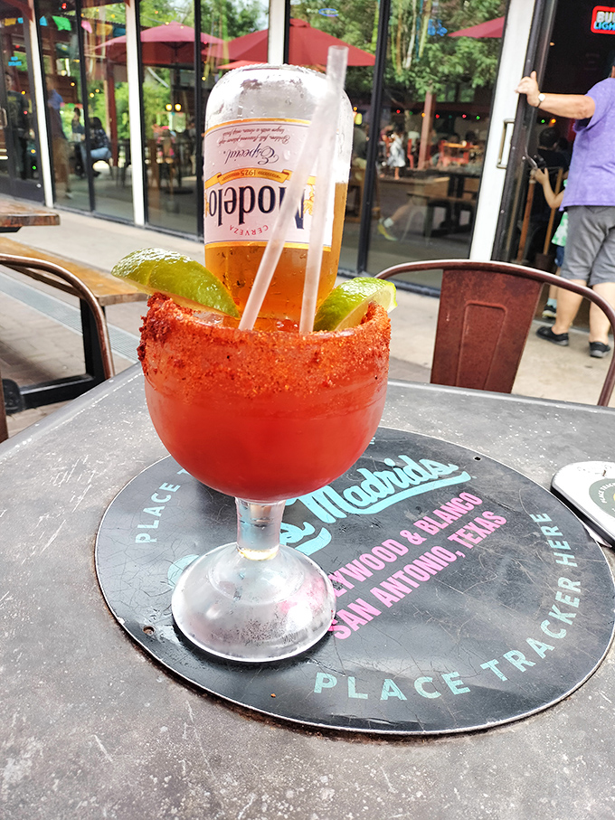A proper Texas-sized Michelada with a chili-salt rim. The beer bottle turned upside down isn't giving up&mdash;it's contributing to the cause.