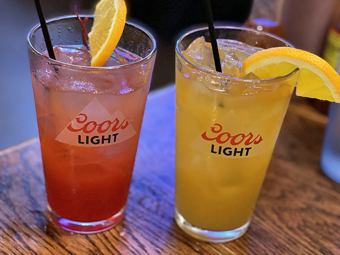 Colorful cocktails in Coors Light glasses—a reminder that in the best local joints, presentation takes a backseat to what actually matters: potency and flavor.
