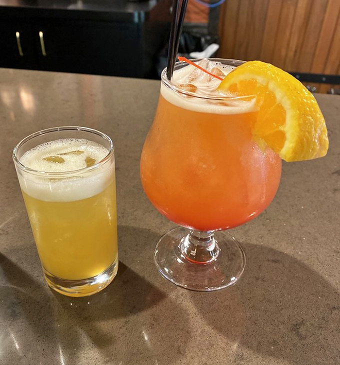 A cold beer and a sunset-colored cocktail – because properly appreciating barbecue requires proper hydration strategies.