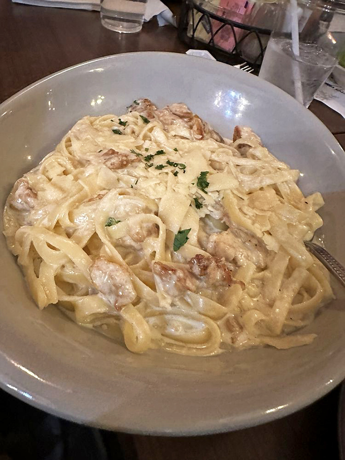 Fettuccine Alfredo that doesn't whisper "creamy"—it announces it with a megaphone, each pasta ribbon glistening like it just won a dairy Olympics.