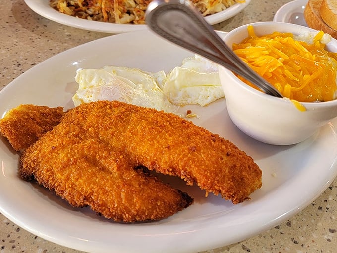 Crispy fish fillets with sunny-side-up eggs&mdash;proof that breakfast and dinner can coexist beautifully on the same plate.