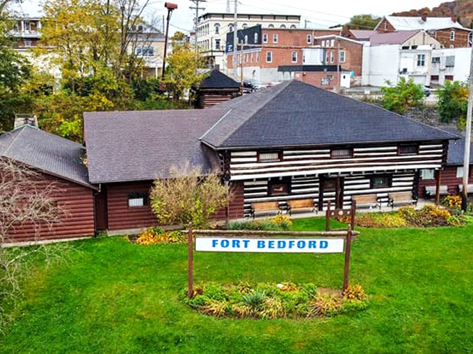 Fort Bedford's replica blockhouse stands guard over history, protecting stories older than your grandmother's secret recipes.