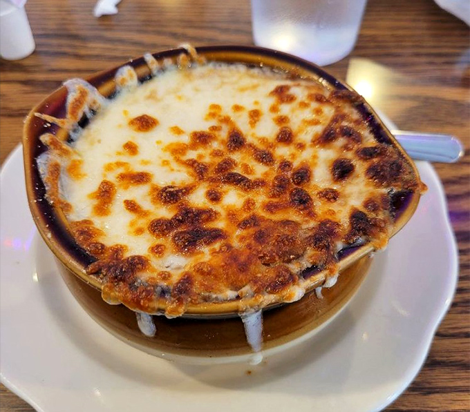 French onion soup with a cheese cap so perfectly browned, it deserves its own standing ovation. Spoon-breaking satisfaction guaranteed.