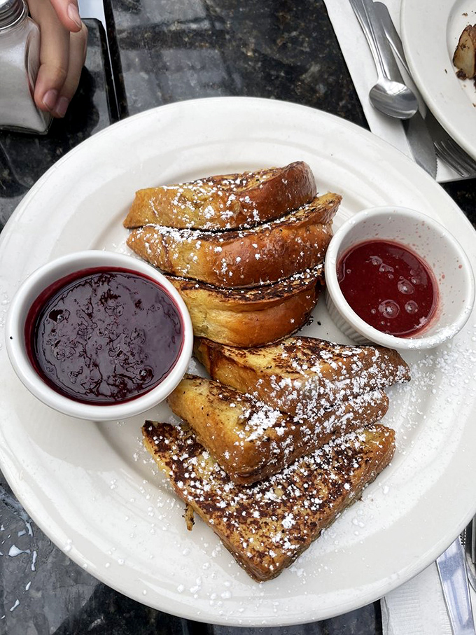 French toast that's achieved that mythical balance: crispy edges, custardy center, and two dipping sauces because sometimes life demands options.