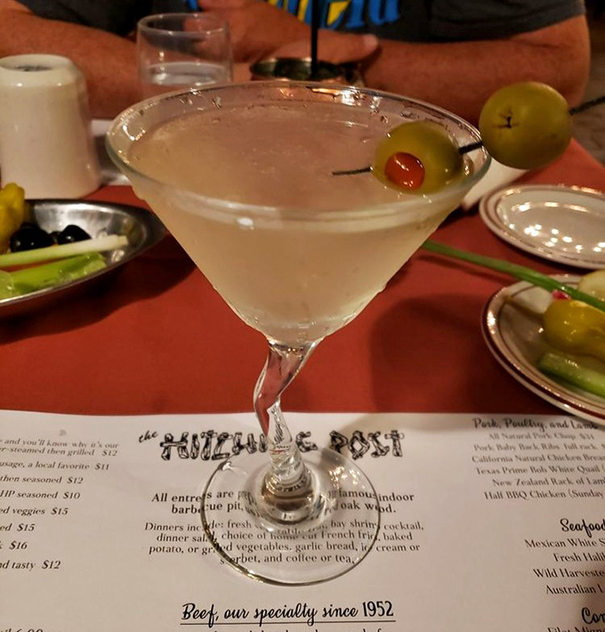 A properly chilled martini with olives standing at attention&mdash;civilization's perfect answer to barbecue-induced thirst.