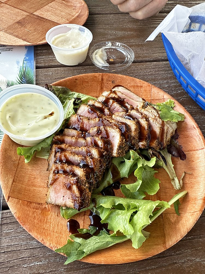 Grilled tuna that's getting the VIP treatment – seared on the outside, blushing on the inside, resting on a bed of greens.