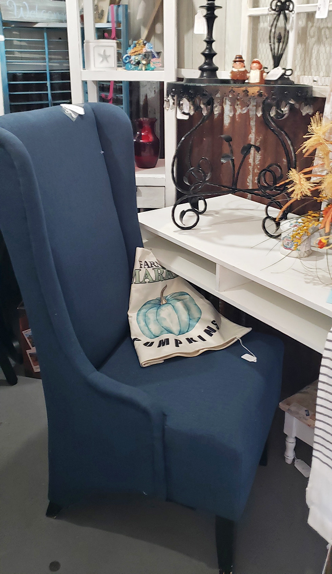 A navy wingback chair paired with a farmhouse pumpkin pillow&mdash;the furniture equivalent of comfort food with a seasonal twist.