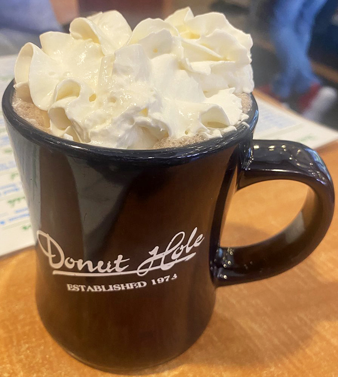 That's not just hot chocolate, it's a warm hug in a branded mug. The whipped cream mountain on top? The chef clearly understands joy.