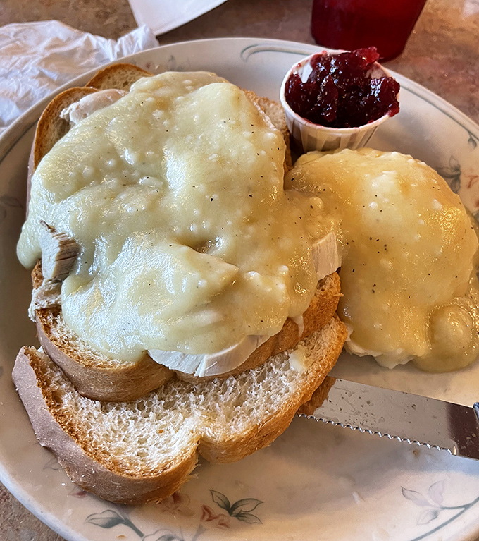 Open-faced hot turkey sandwich &ndash; comfort food architecture at its finest, where melted cheese creates a golden canopy over toasted bread.