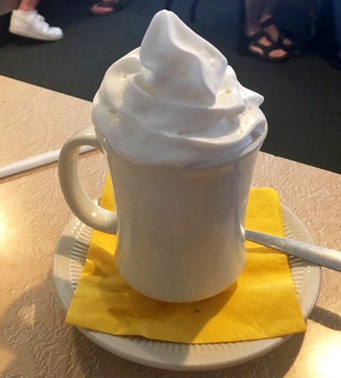 Whipped cream mountain atop hot chocolate – the kind of simple pleasure that makes adults remember why being a kid was awesome.