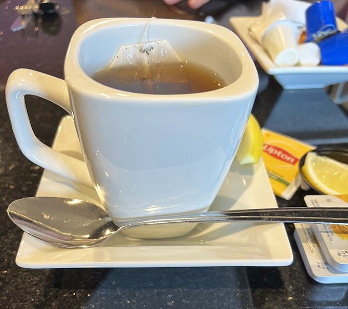 Tea service that respects the ritual—proper cup, saucer, and lemon slice. Civilization begins with these small morning dignities.