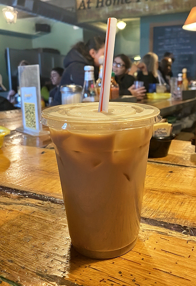 Coffee gets dressed up for the occasion &ndash; this iced vanilla latte sitting pretty on weathered wood, ready to fuel your Philadelphia adventures.