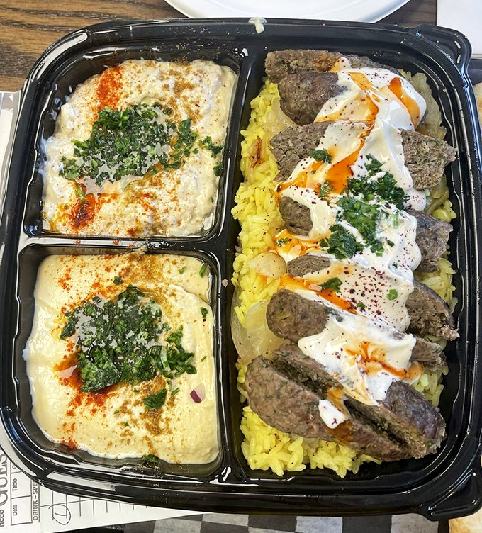 Kafta kabobs lounging on a bed of yellow rice with hummus on the side&mdash;a Middle Eastern feast that feels like a warm hug.