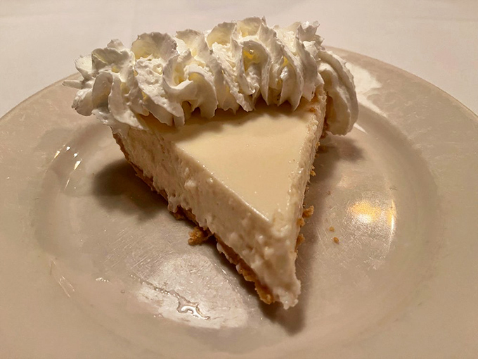 Key Lime Pie that strikes the perfect balance between sweet and tart. That dollop of whipped cream isn't just garnish—it's the cloud this slice deserves to float on.