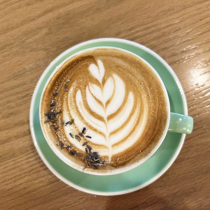 Latte art so pretty you almost feel guilty disturbing it. The pale mint cup cradles a masterpiece of foam and lavender-infused comfort.