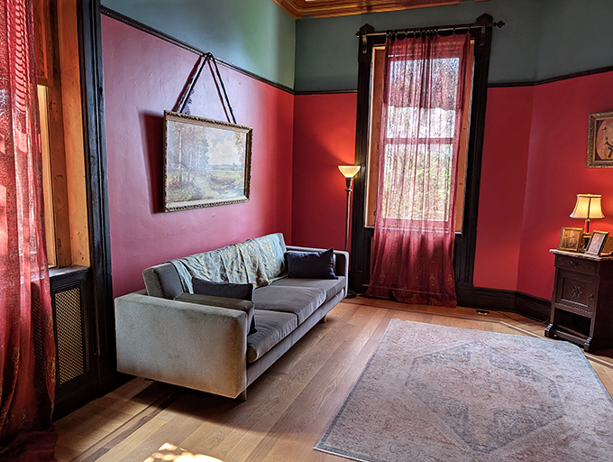 Sunlight streams across herringbone floors in this elegantly appointed sitting room where Victorian sensibilities meet modern comfort.