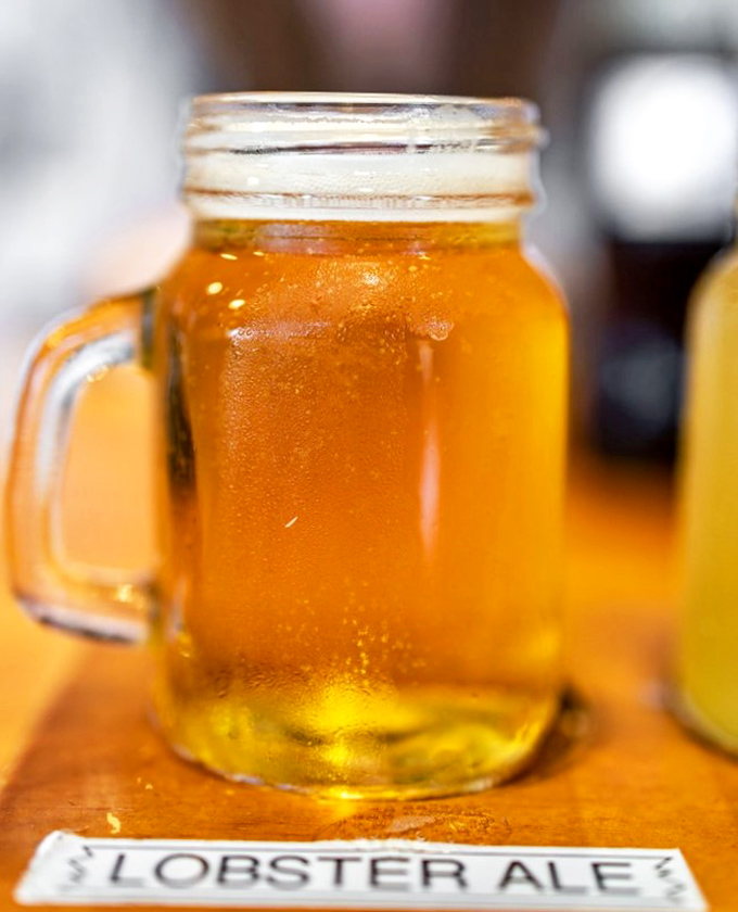 A mason jar of golden Lobster Ale—because what pairs better with ocean treasures than a cold brew? The condensation tells you it's ready.