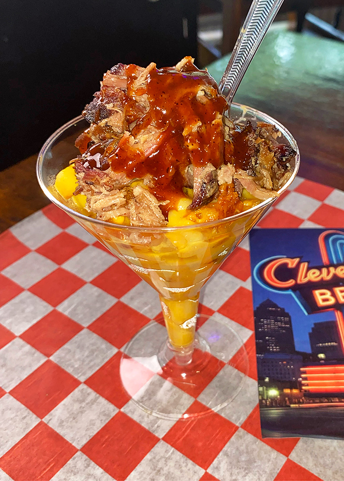 BBQ innovation at its finest: Mac and cheese topped with smoked meat in a martini glass. Fancy meets finger-lickin' in perfect harmony.