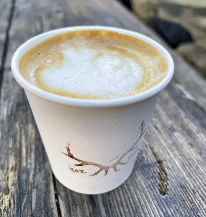 Coffee with a view &ndash; this isn't just caffeine, it's mountain-air therapy in a cup emblazoned with antlers, because of course it is.
