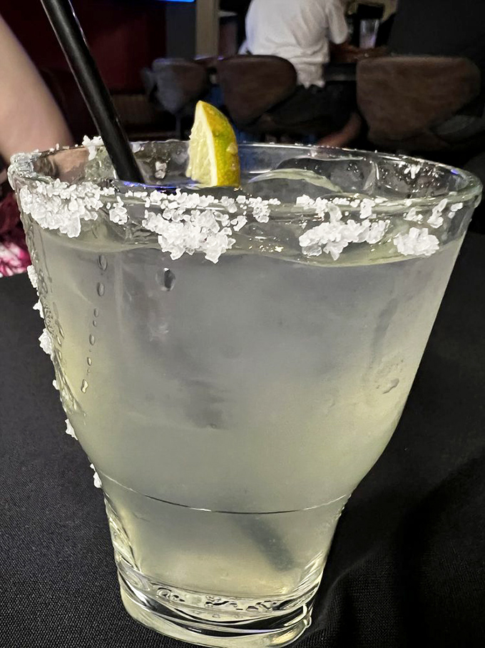 A proper margarita with a salt-crusted rim and lime wedge—because sometimes you need something bright and zesty to cut through all that delicious richness.