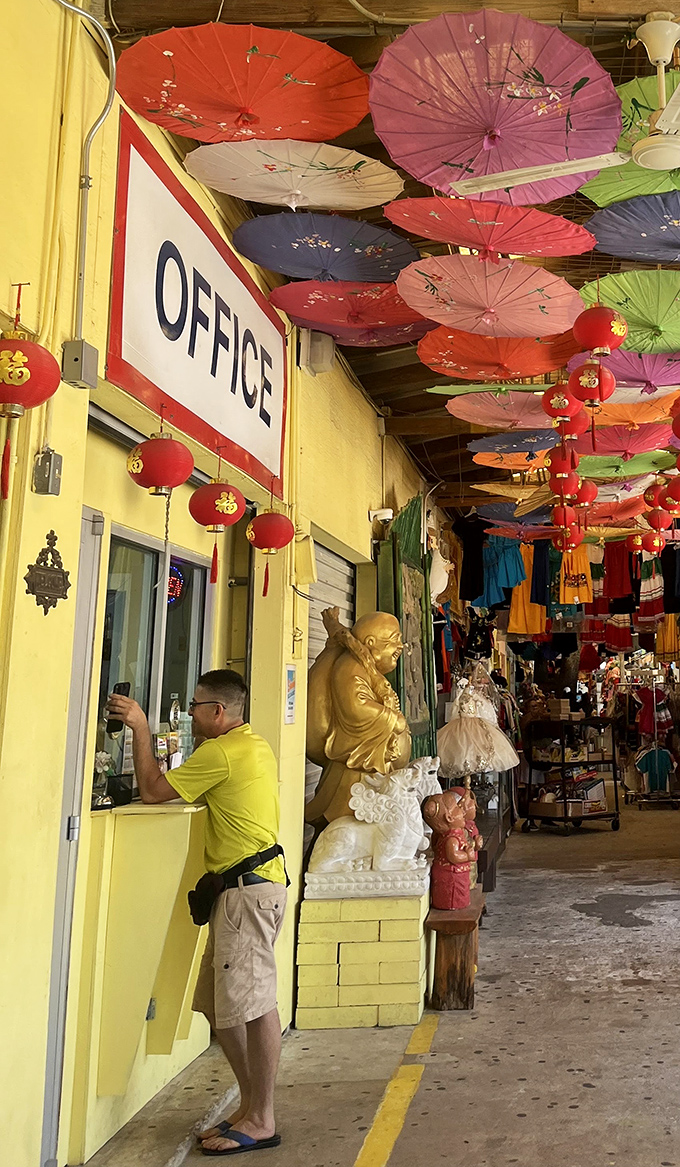 Where East meets West! Colorful paper parasols and Chinese lanterns create a cultural canopy above the market's administrative hub.