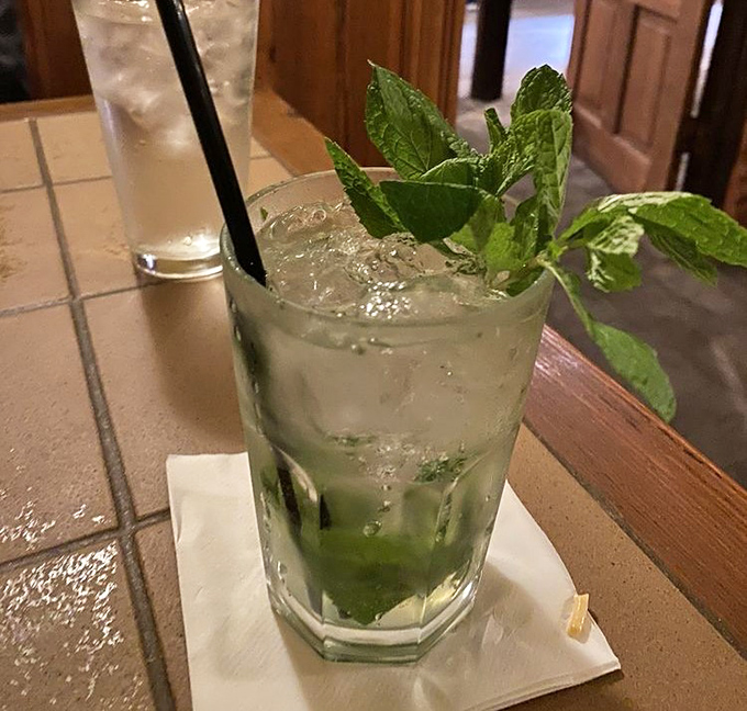 Fresh mint leaves dance atop this crystal-clear mojito, offering the perfect palate cleanser between bites of smoky, savory perfection.
