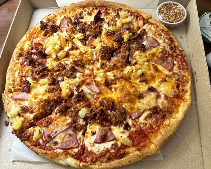 Hawaiian pizza elevated to volcanic heights with ham, pineapple, and a perfect cheese pull. Even pineapple-on-pizza skeptics might convert after this beauty.