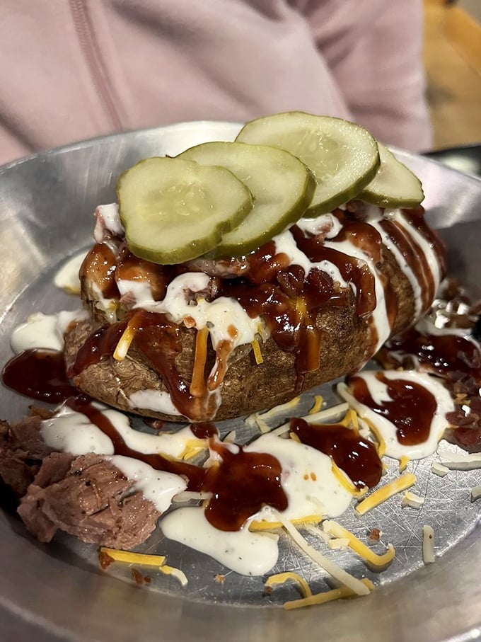 This isn't just a baked potato&mdash;it's a canvas for barbecue artistry, complete with all the fixings and pickle coins for good measure.